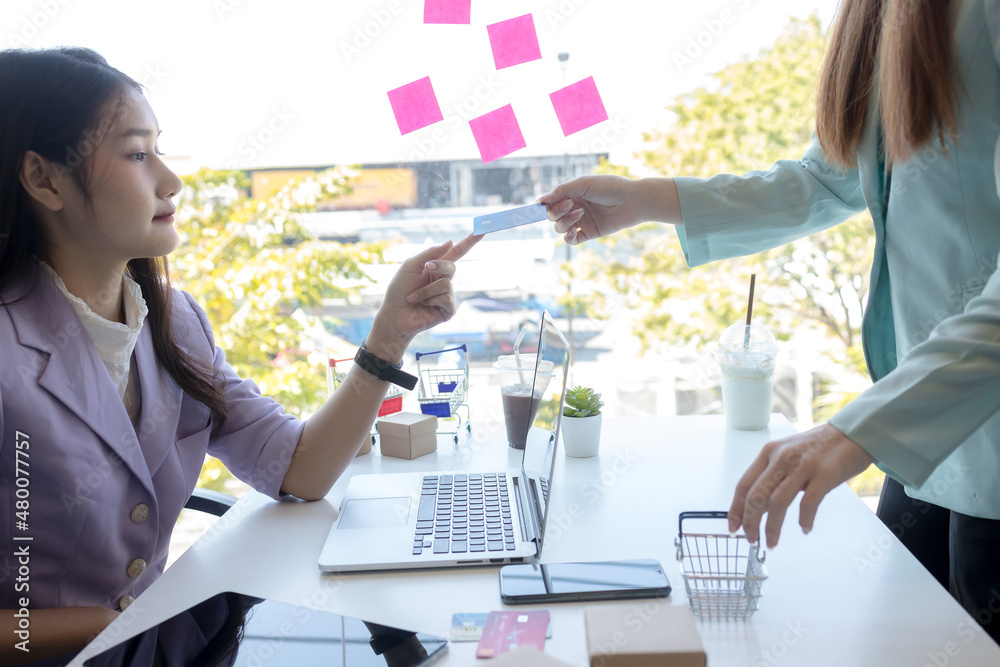 Foto de Asian women counter service staff receiving a credit card from ...