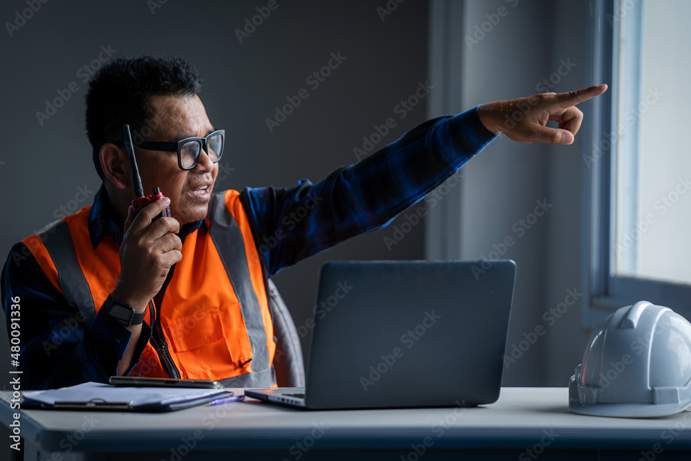 Engineer working on personal computer at construction site. Stock Photo ...