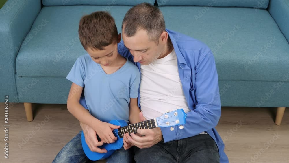 Home hobbies. Authentic people. A happy father teaches his little son ...