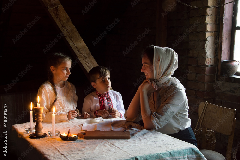 Poor family at the table. Mother gave the children the last piece of ...