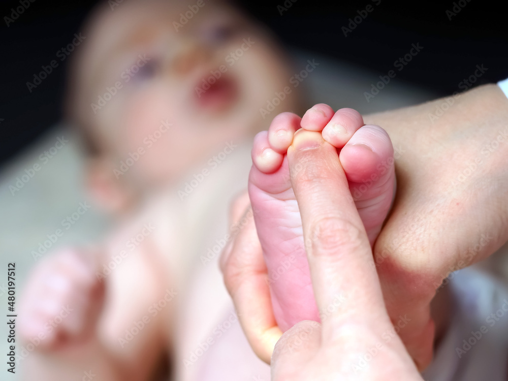 doctor checks the reflexes of a newborn baby on the sole of the foot ...