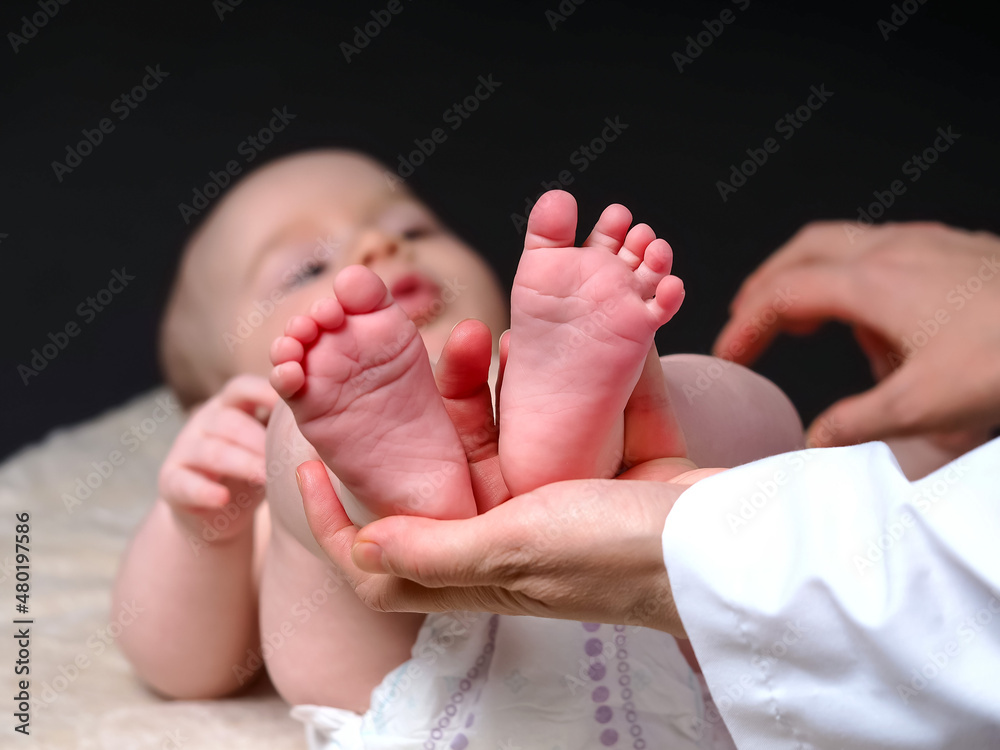 doctor checks the reflexes of a newborn baby on the sole of the foot ...