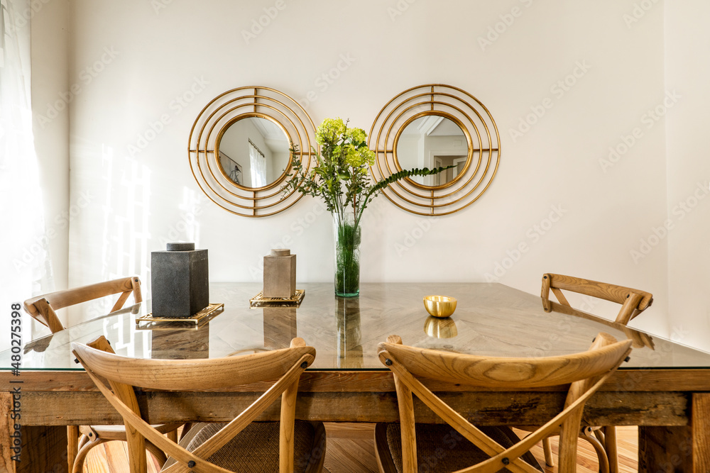 Oak wood dining table with glass top, circular wall mirrors and ...
