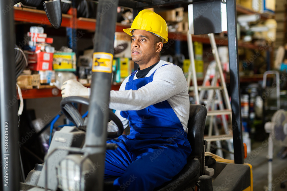 Skilled hispanic worker of building materials warehouse working on ...
