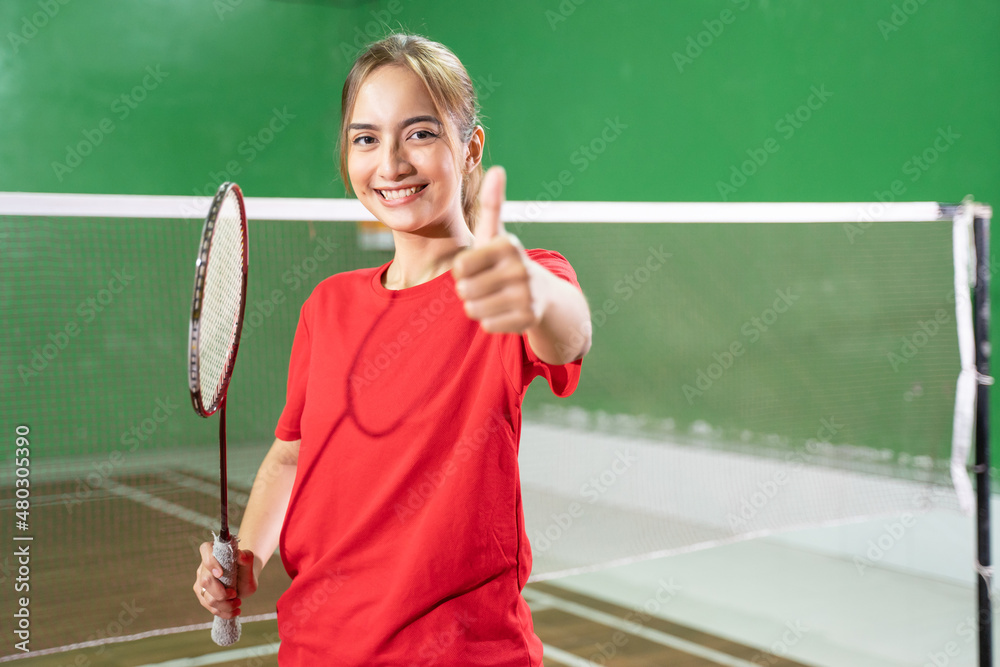 Beautiful girl badminton player with thumbs up holding racket Stock ...