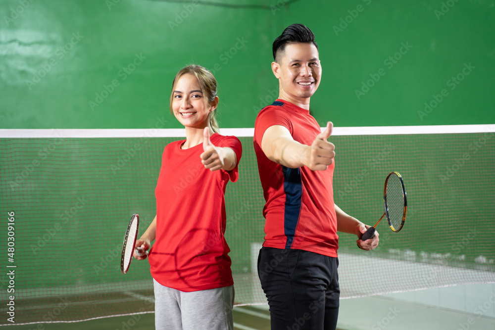 badminton players standing with thumbs up on badminton court Stock ...