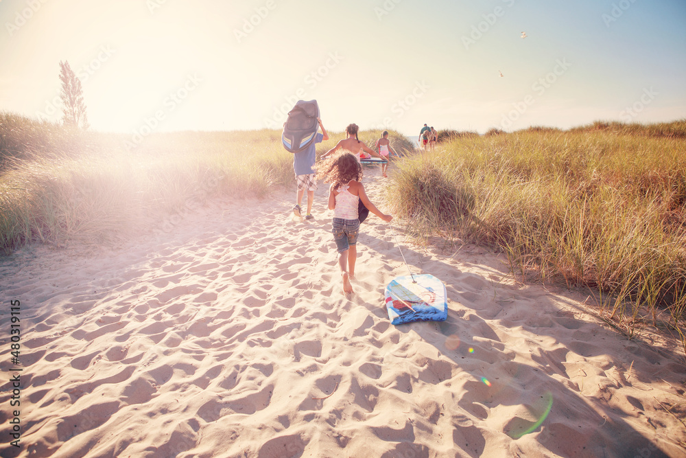 Children carrying body boards up a beachside dune path Stock Photo ...