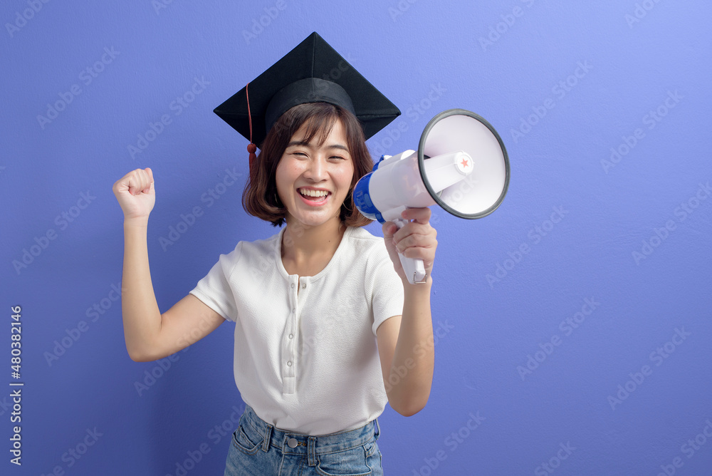 Portrait of graduated asian student holding megaphone isolated purple ...