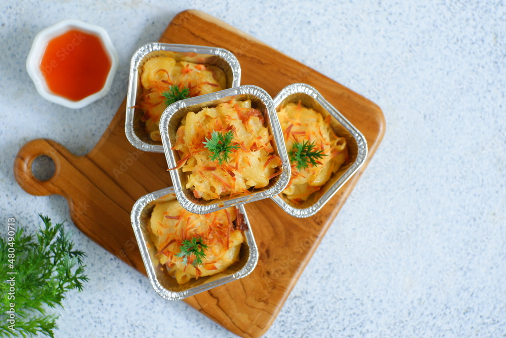 selective focus of baked macaroni and cheese in aluminium foil cup ...