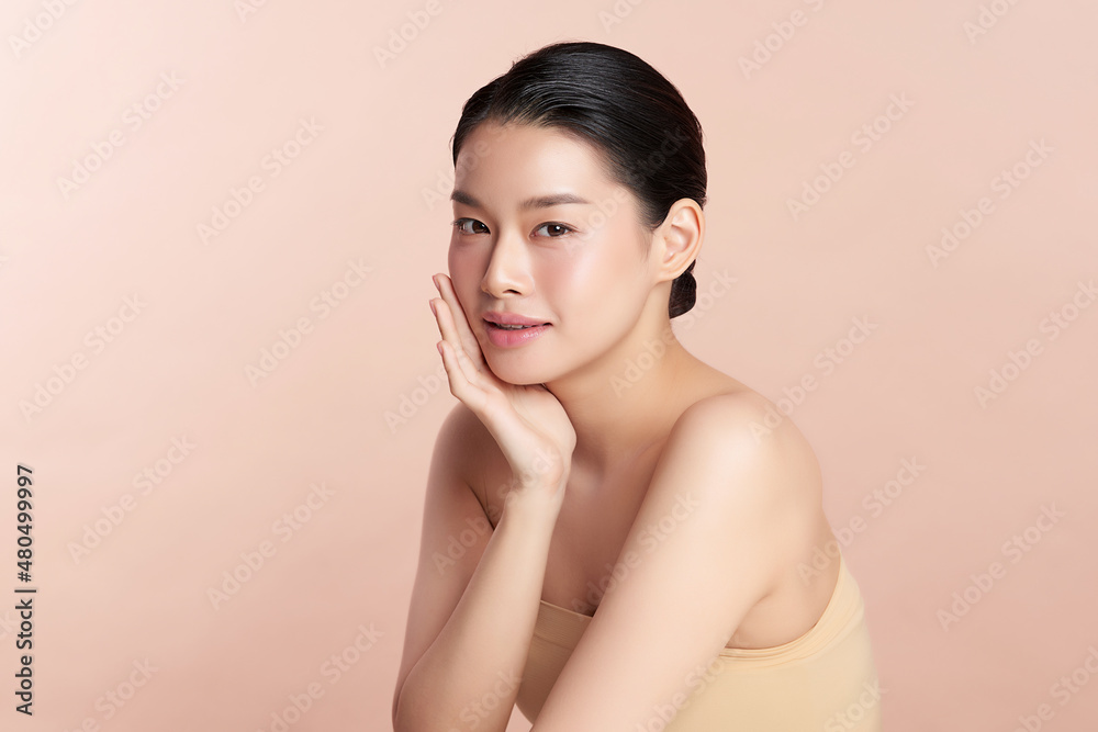 Beautiful young asian woman with clean fresh skin on beige background ...