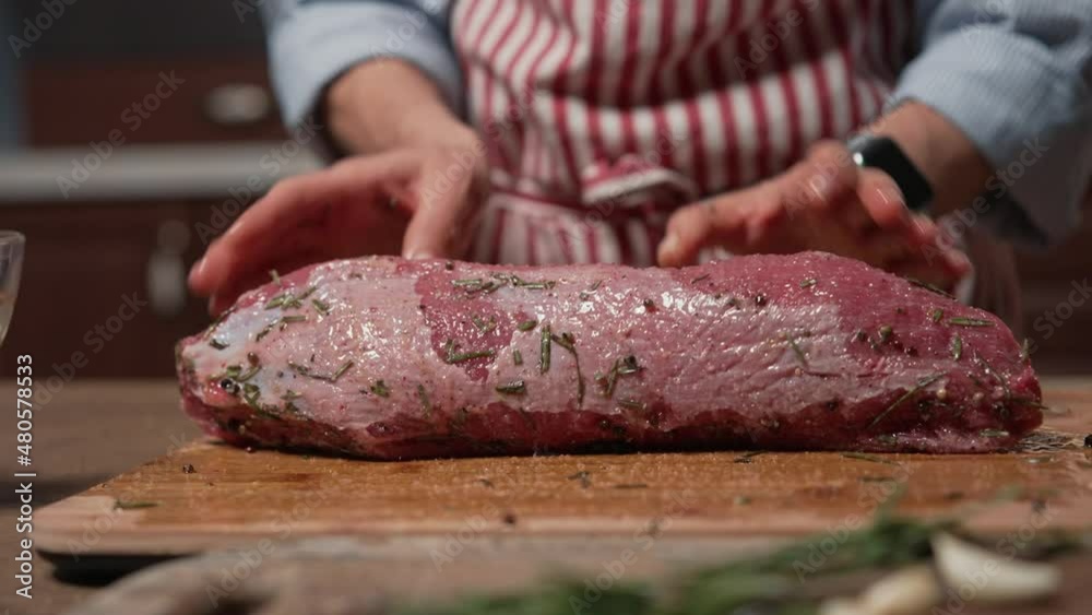 The chef woman pours oil and spices to the beef. Top view food ...