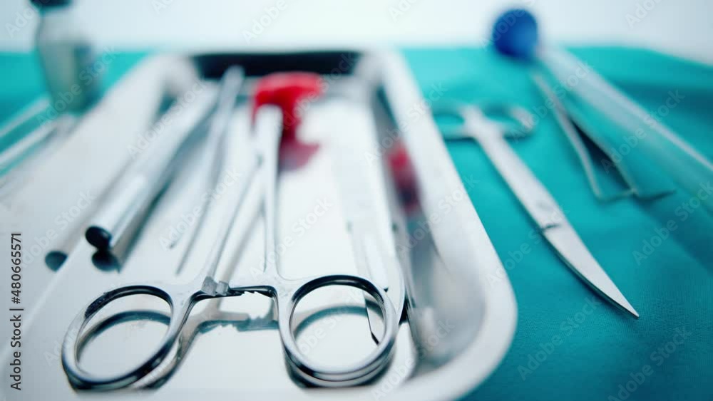 A surgeon is performing a surgery. Medical instruments in steel tray on ...