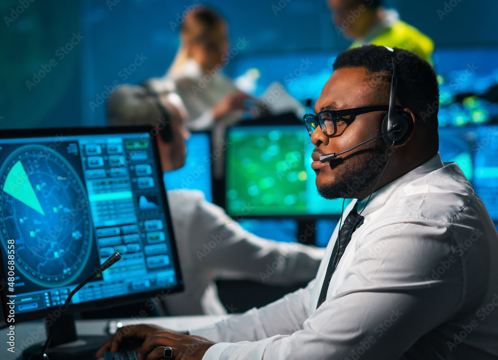 Aircraft flight control officer monitors the approach of aircraft from ...