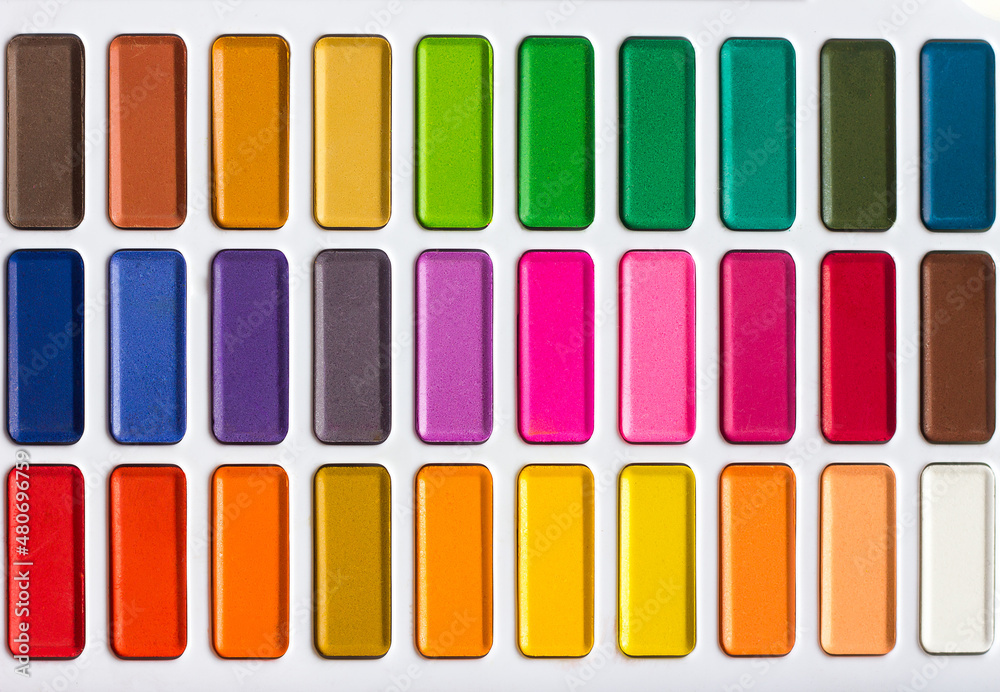 Palette of bright multi-colored watercolors close-up, artist's tools ...