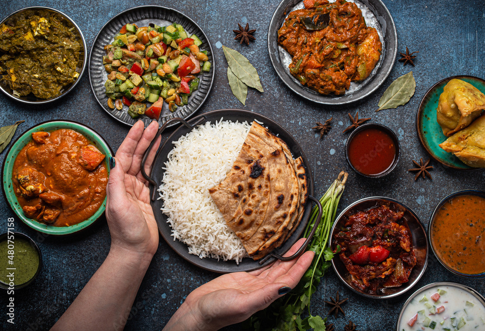 Assorted Indian ethnic food buffet on rustic concrete table from above ...