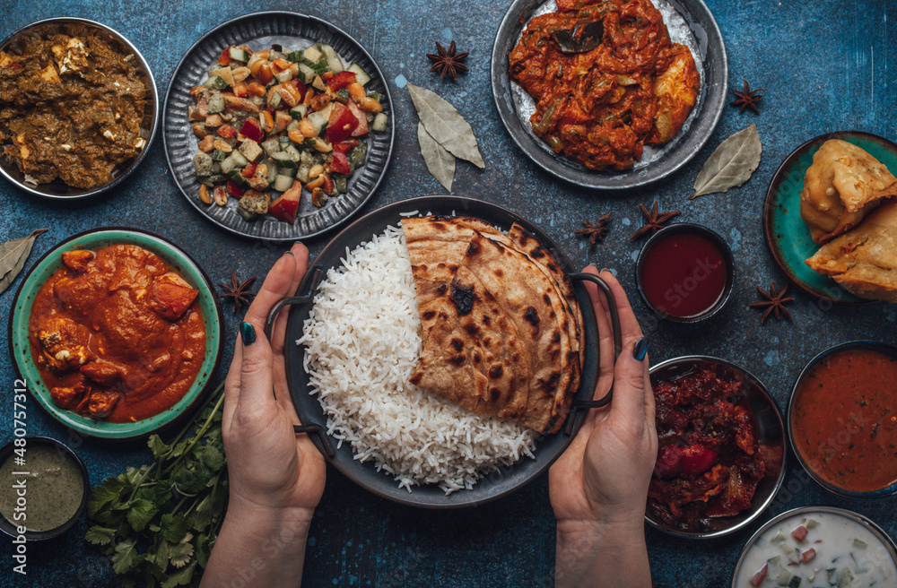 Assorted Indian ethnic food buffet on rustic concrete table from above ...