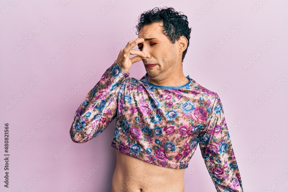 Handsome man wearing make up wearing fashion clothes smelling something ...