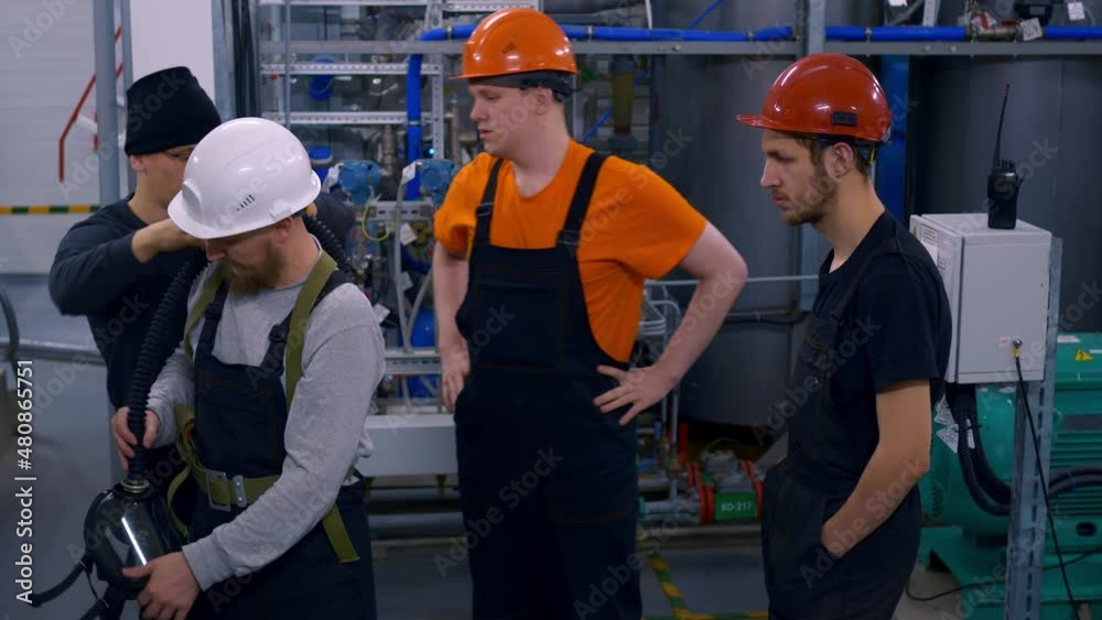 Training of personnel in safety engineering. One worker puts on a ...