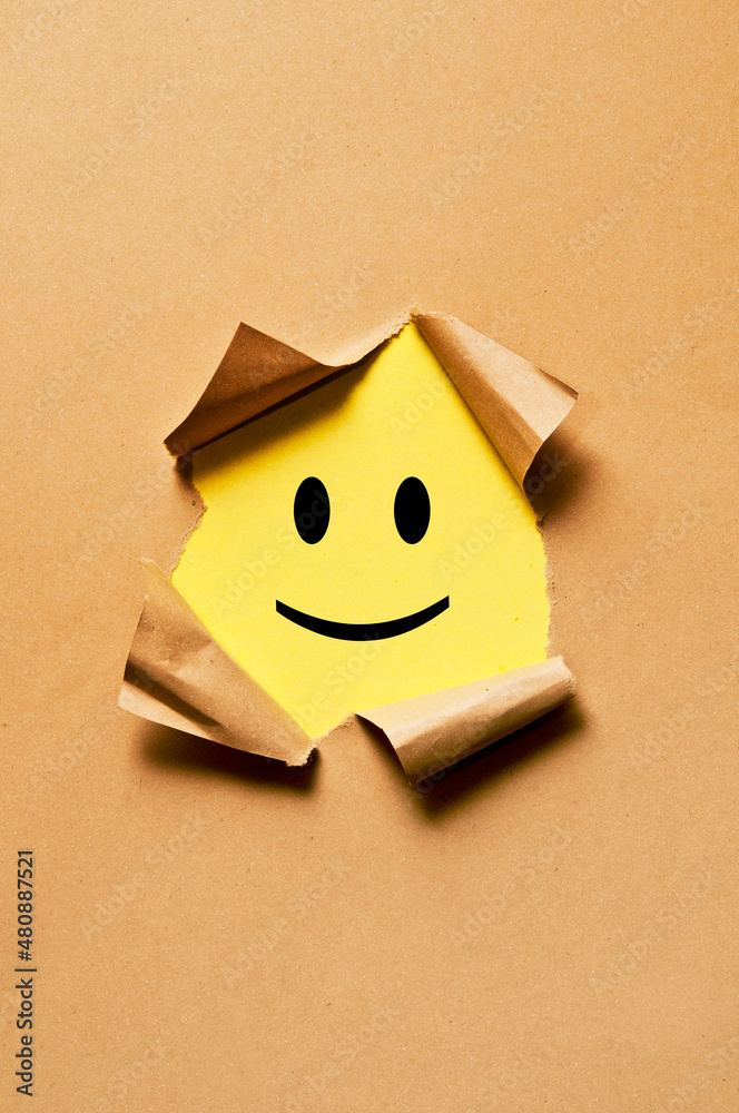 ripped paper revealing a smiley emoticon or emoji Stock Photo | Adobe Stock