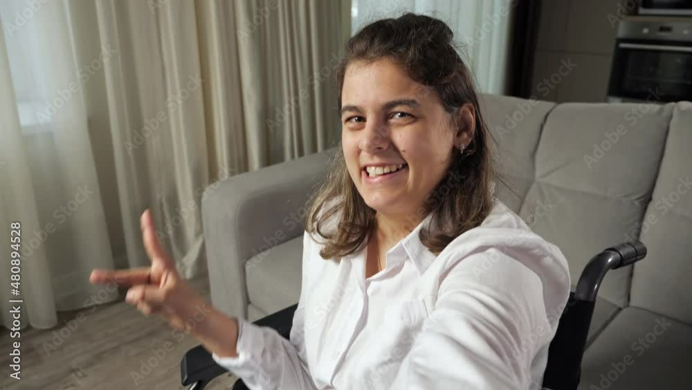 Disabled woman with cerebral palsy makes fingers Victory sign and ...