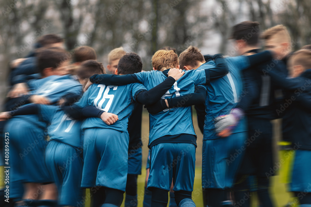 Motivated youth soccer team cheering on court. Players huddling in a ...