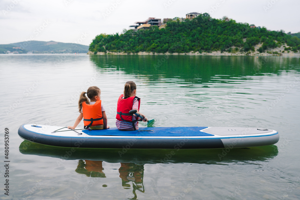 Summer outdoor activities with kids concept. Two girls sitting on ...