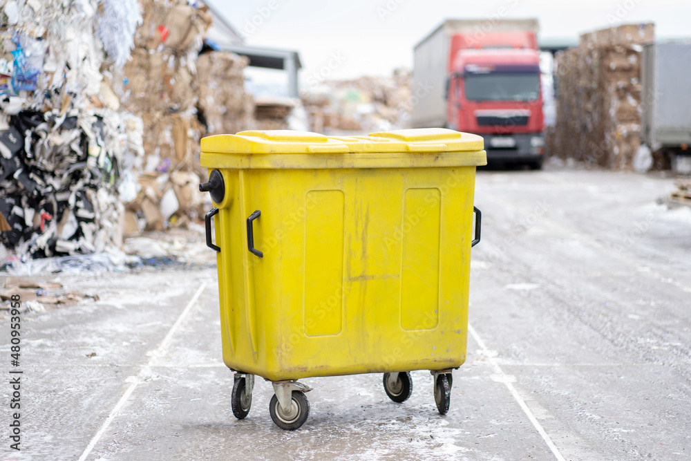 Photograph of a trash can against a background of rubbish and cardboard ...