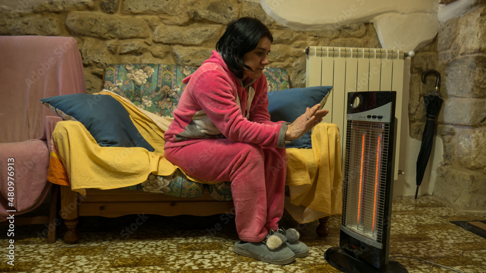 nice chilly woman in pink pajamas lying on the sofa at home warming her ...