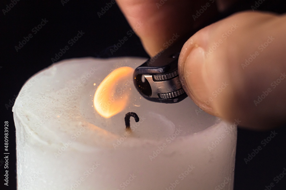 Hand holding burning lighter with fire and sparks. Lighting candle on ...