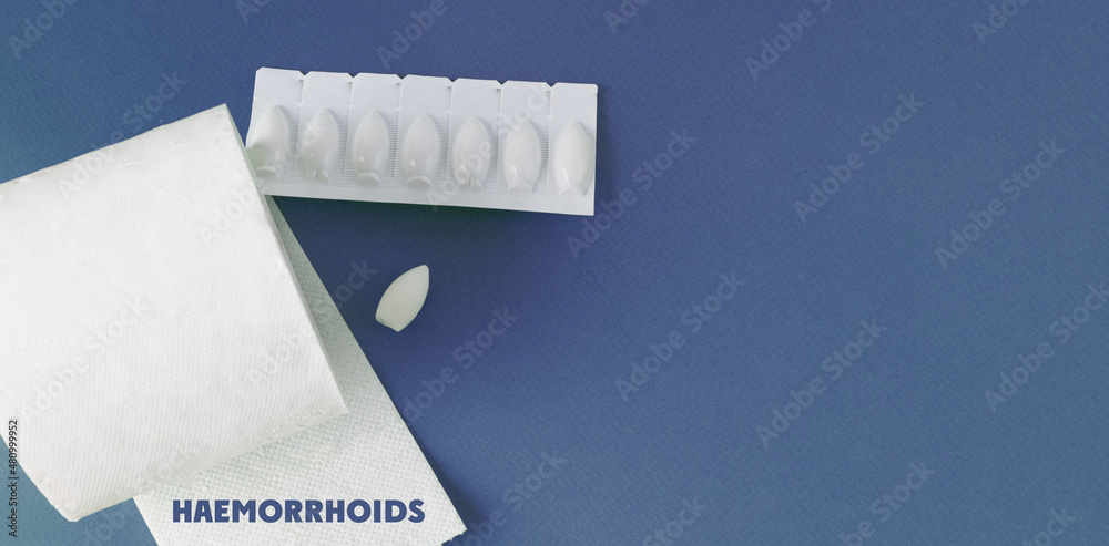 Toilet paper and rectal suppositories on a bright background with copy ...