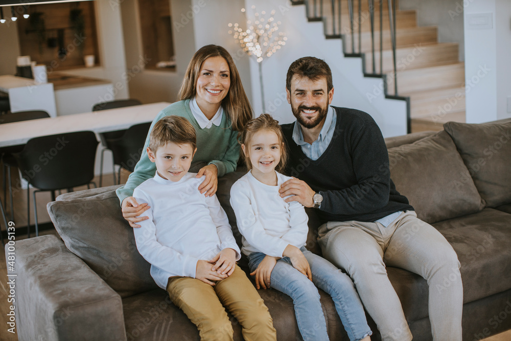 Happy family with two kids enjoy time together on couch in living room ...