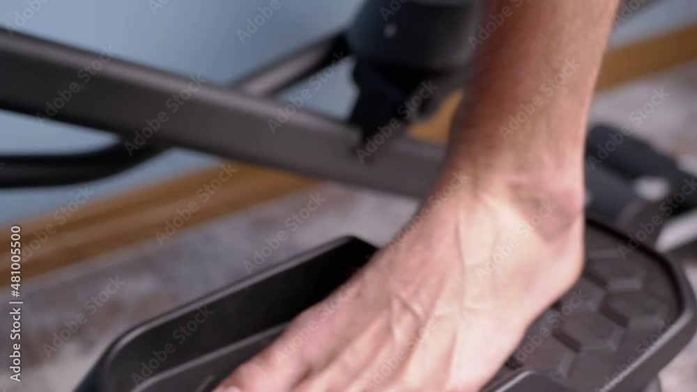 Barefoot Male Feet Pedaling On Elliptical Cross Trainer Simulator At