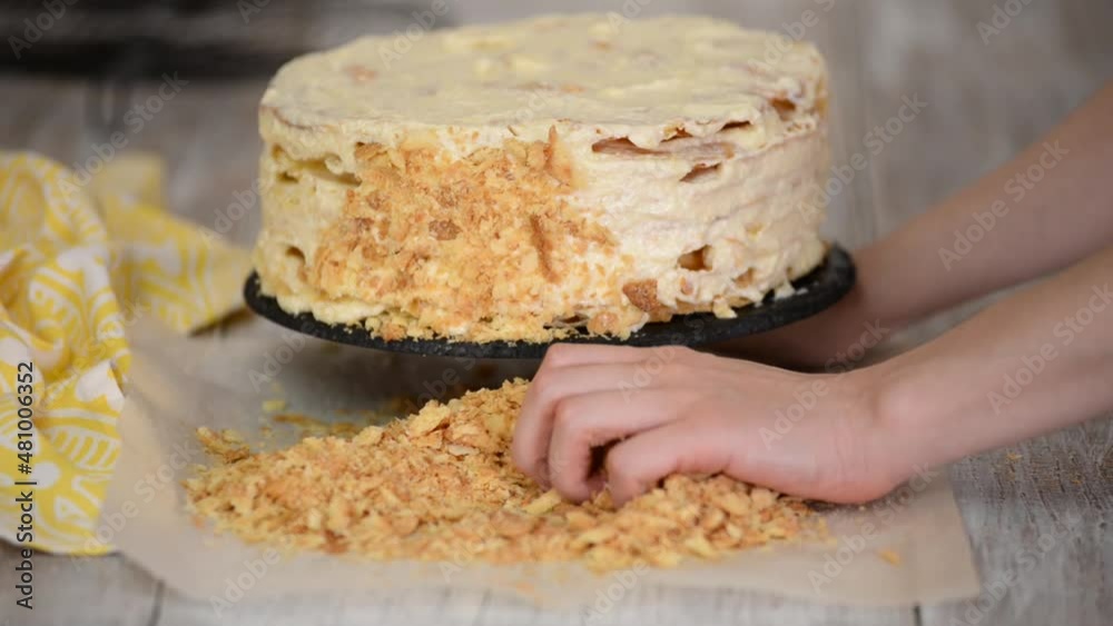 Pastry chef making napoleon cake. Covering Napoleon cake with crumbled ...