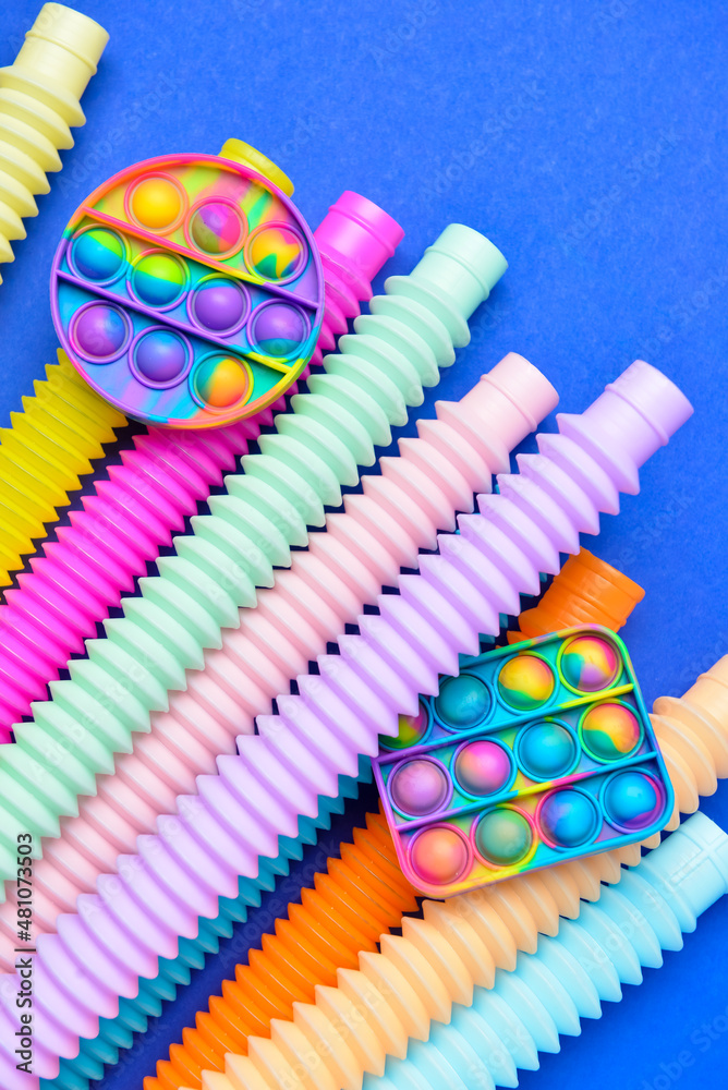 Colorful Pop Tubes and Pop it fidget toys on blue background Stock ...