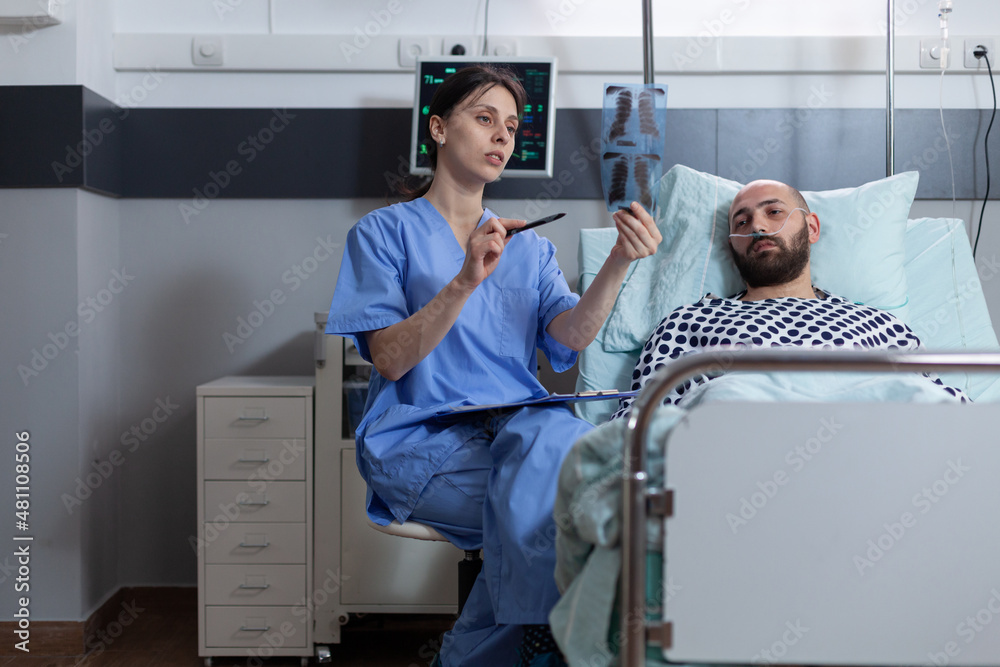 Hospital nurse looking at chest xray providing medical health care to ...