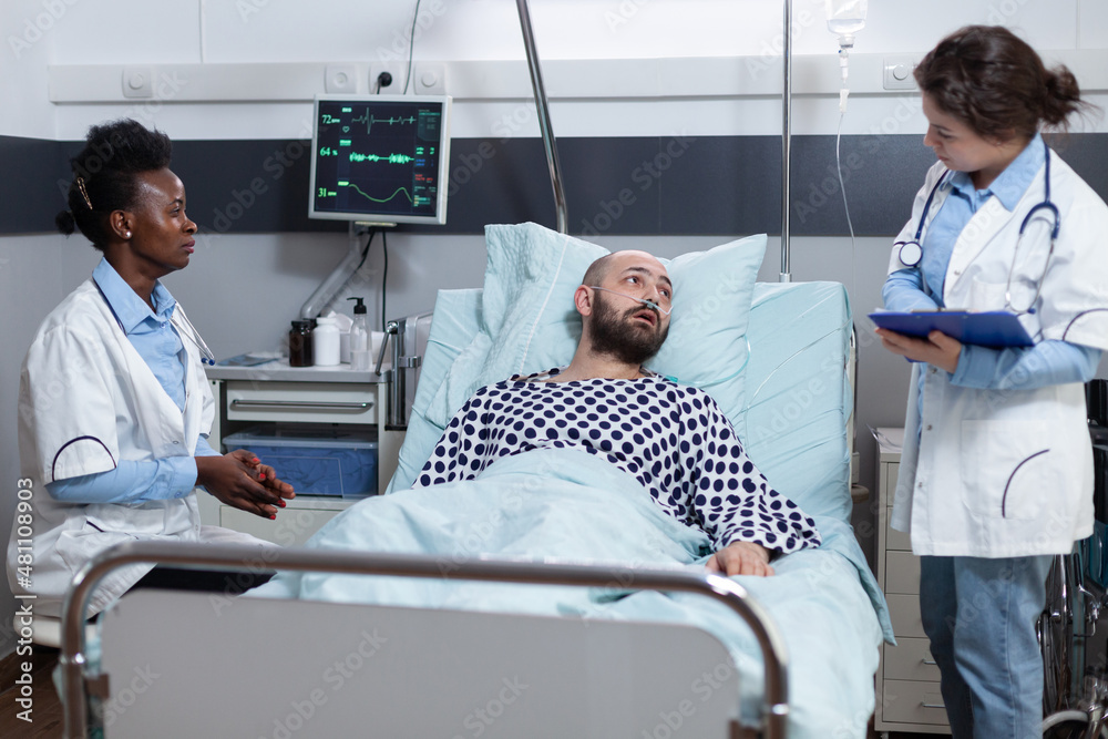 Doctor holding clipboard with clinical data consults recovering patient ...