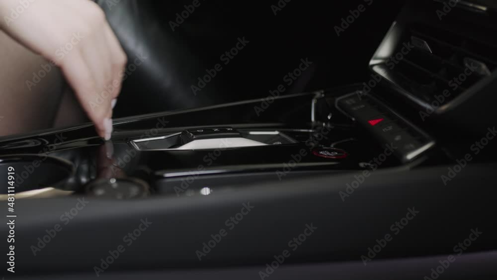 a woman's hand starts an electric car by placing her finger on the ...