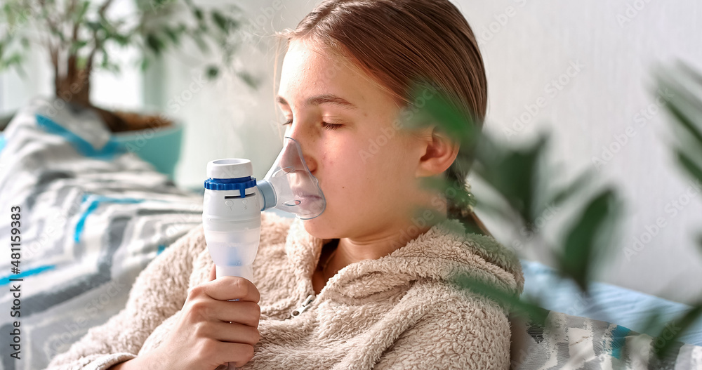 Teenage girl makes inhalation with a nebulizer equipment. Sick child ...