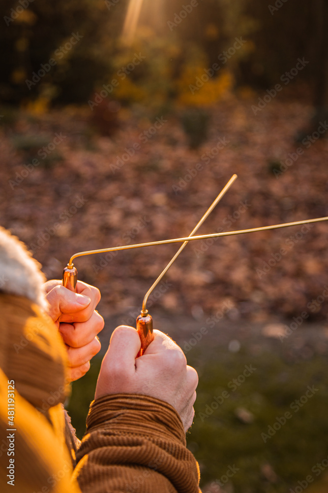 Man holding dowsing rod outside Stock Photo | Adobe Stock