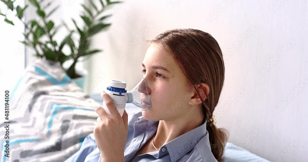 Teenage girl makes inhalation with a nebulizer equipment. Sick child ...