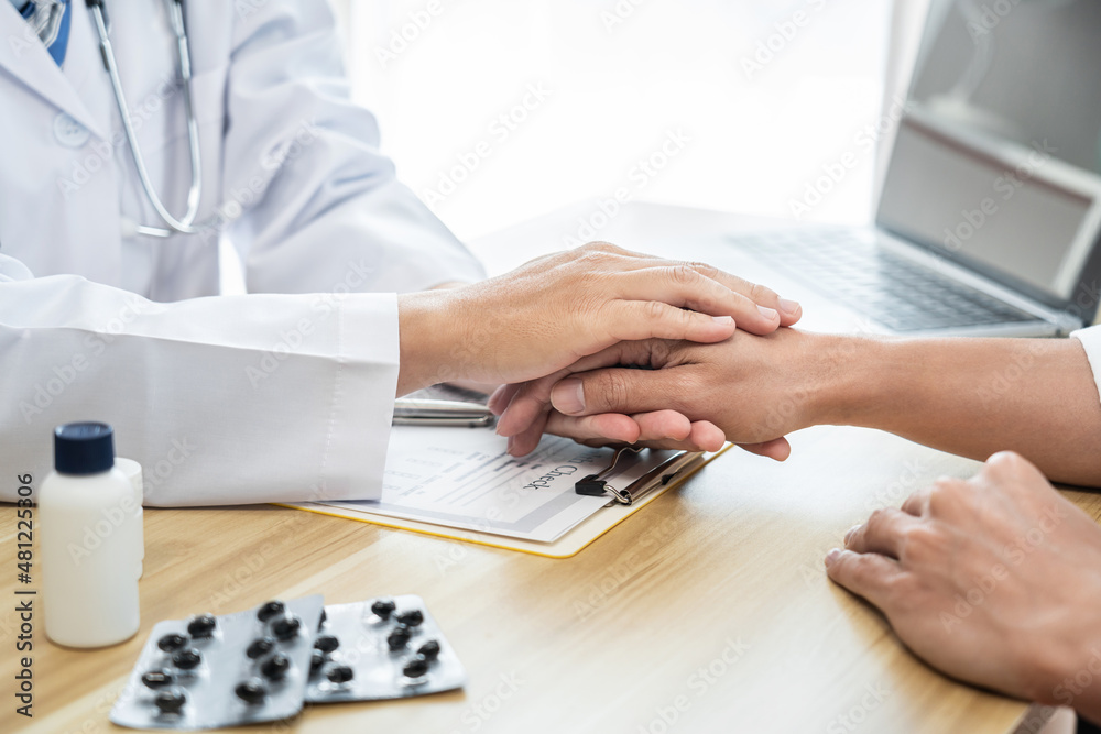 Doctor touching patient hands for encouragement and empathy on the ...