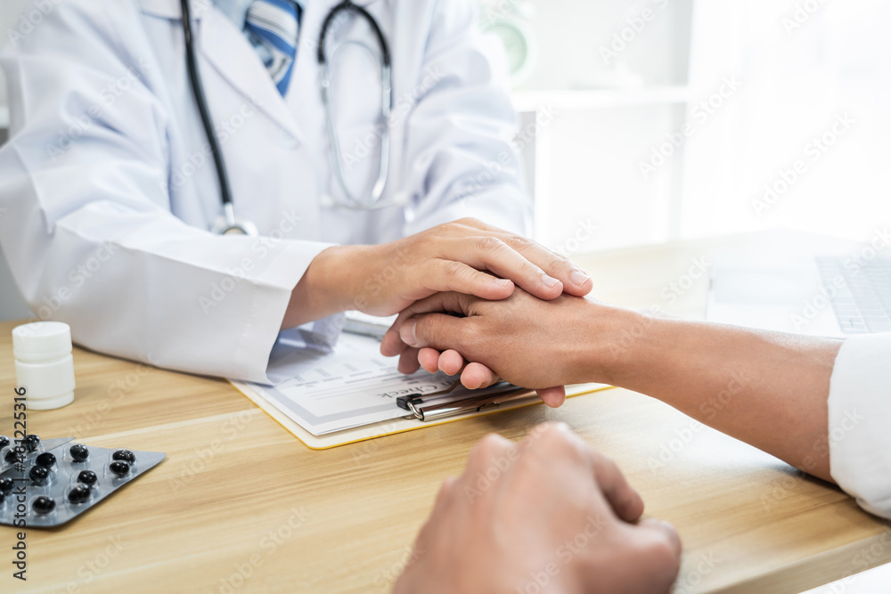 Doctor touching patient hands for encouragement and empathy on the ...