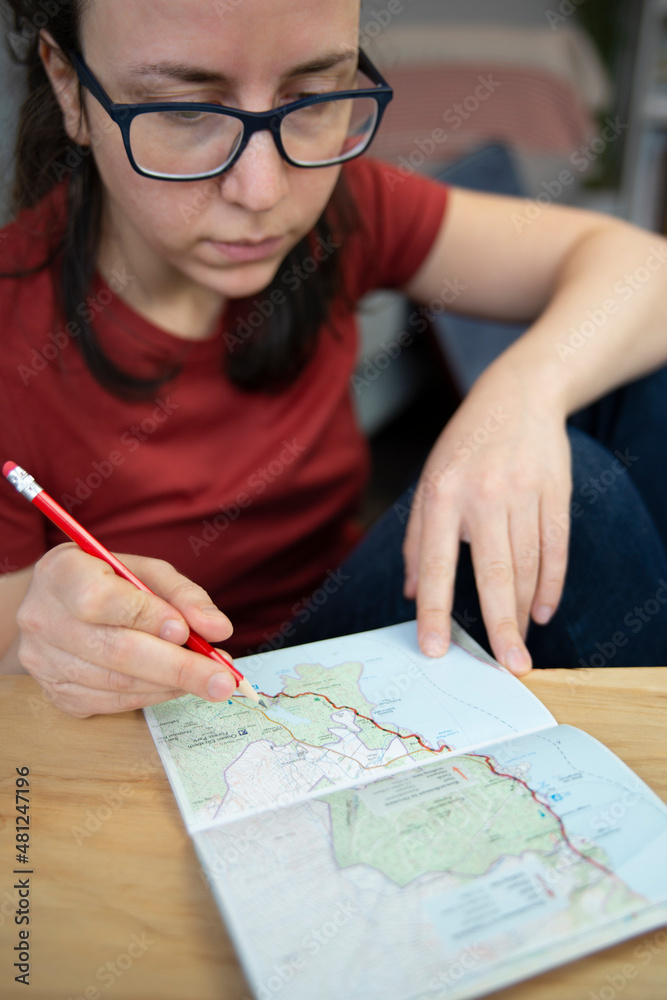 Person planning a trip with a map and a guidebook Stock Photo | Adobe Stock