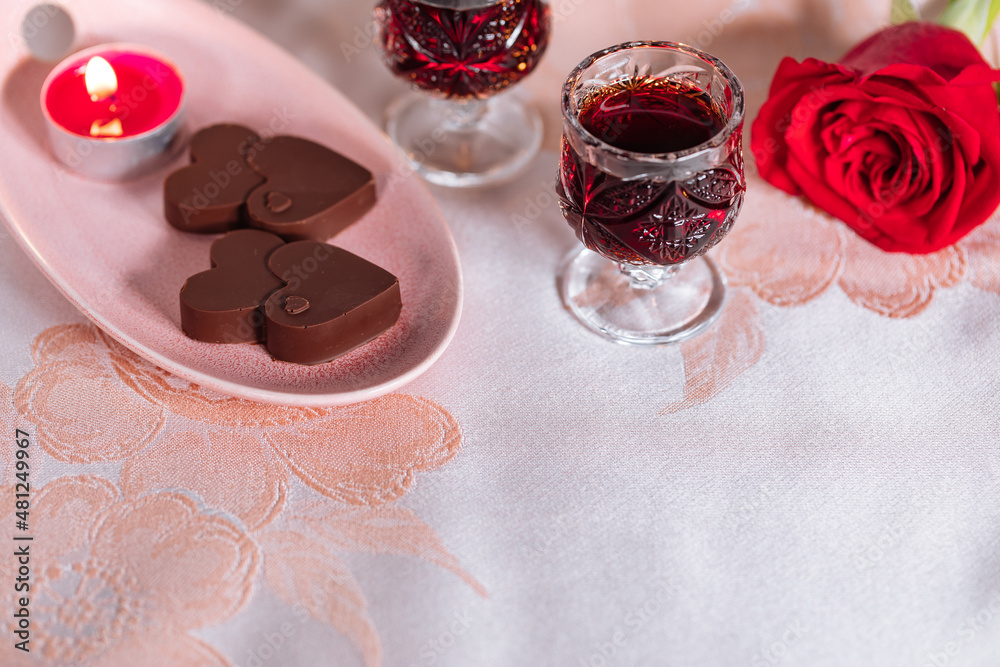 Heart shaped pralines with two cherry liqueur and red roses in romantic ...