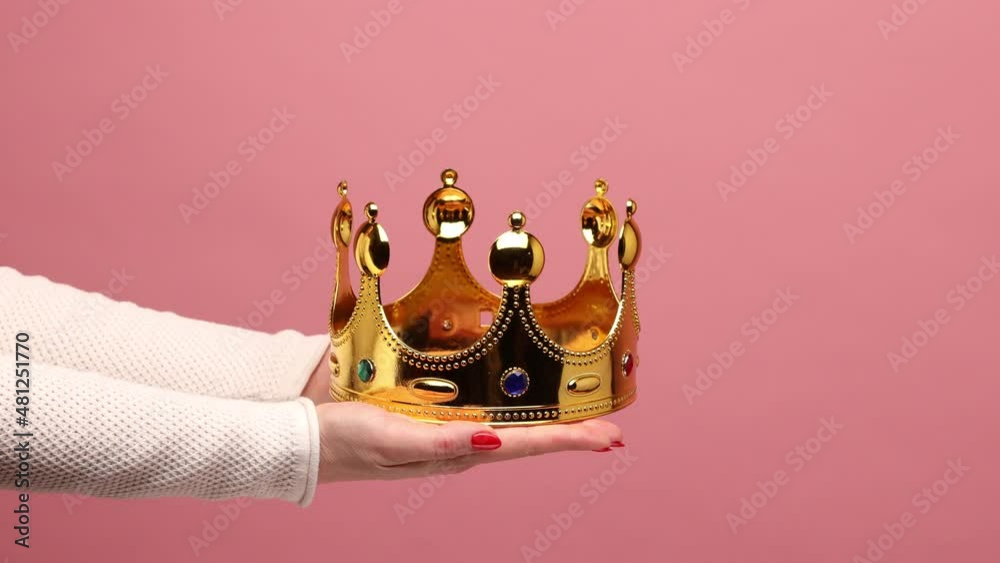 Profile side view closeup of woman hand holding golden crown for king ...