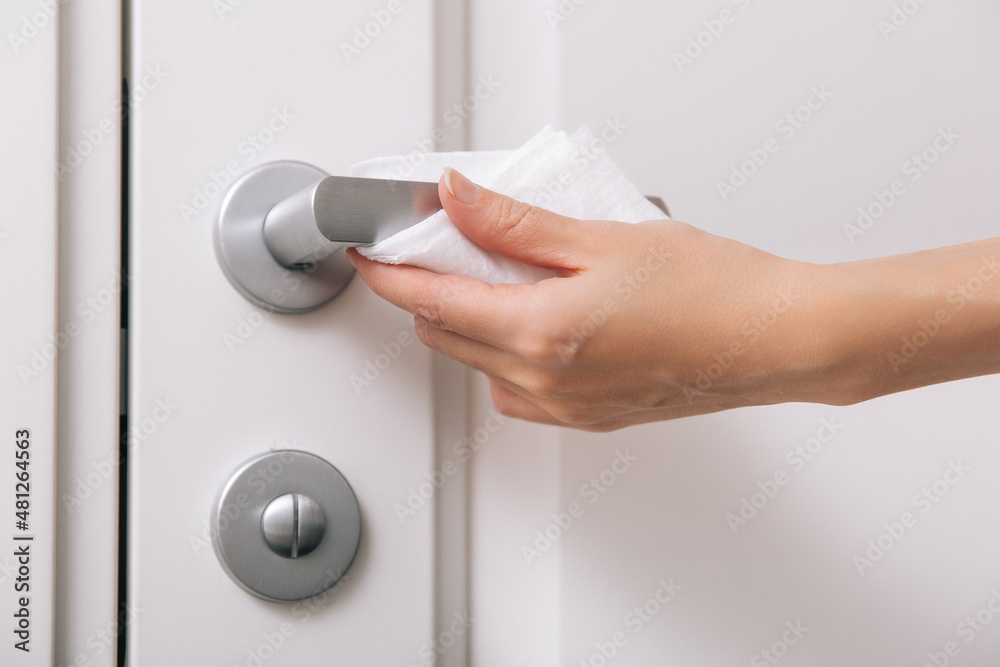 Cleaning door handles with an antiseptic wet wipe and gloves. Sanitize ...