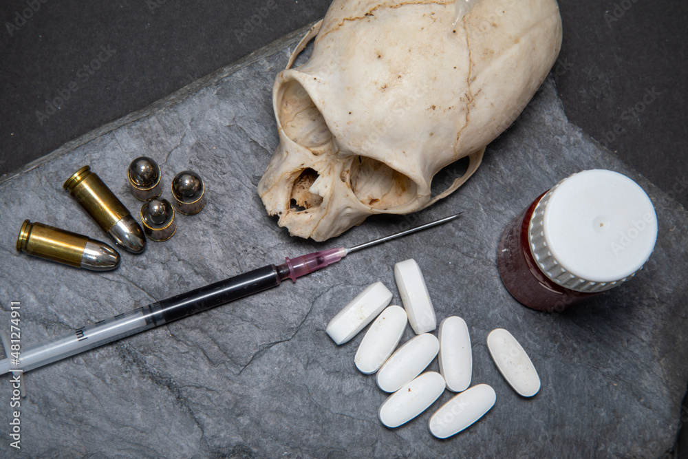 Skull and pistol with bullets against a black stone background (monkey ...