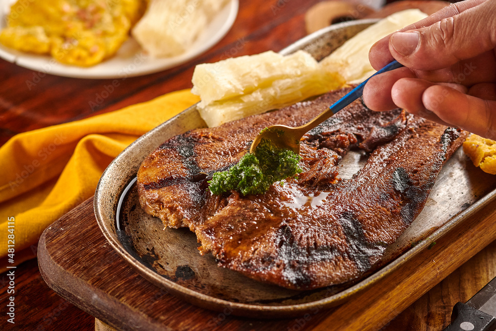 mano colocando chimichurri en una carde de res Stock Photo | Adobe Stock