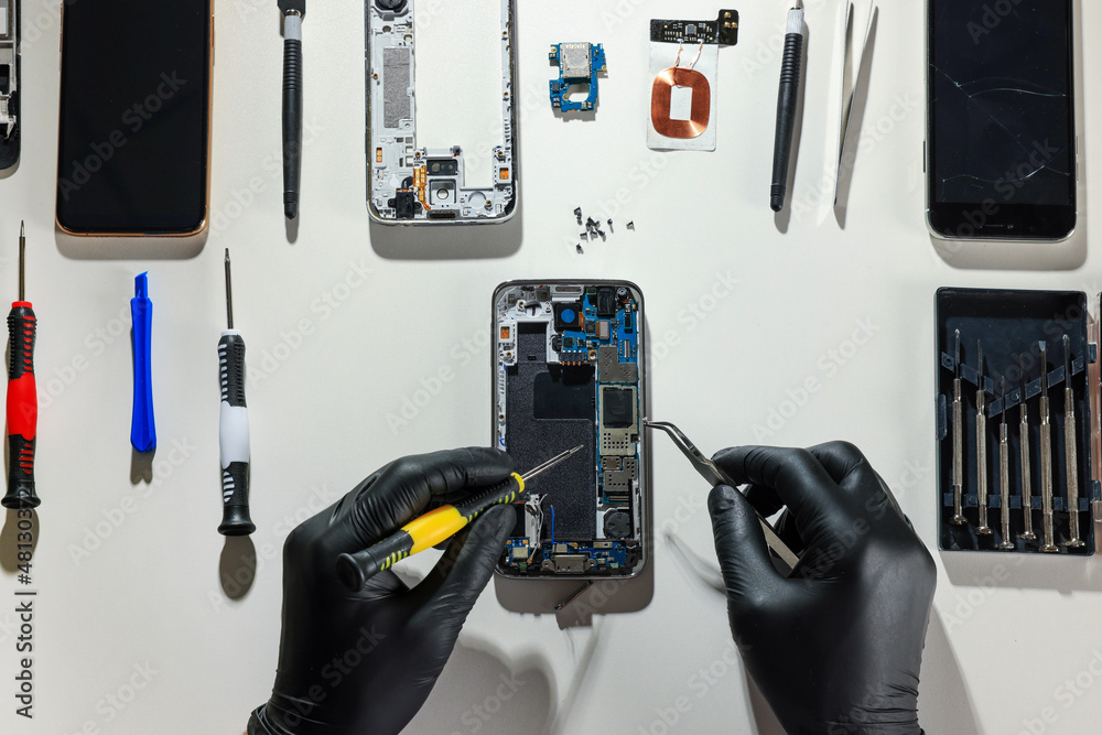 Technician repairing broken smartphone at white table, top view Stock ...