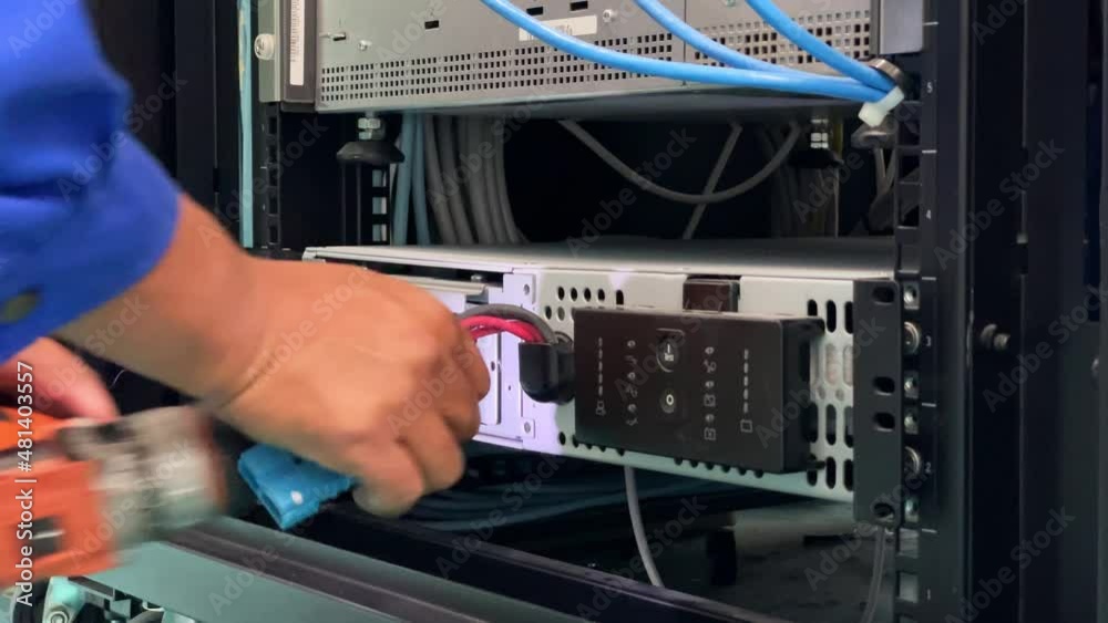 Technician installing and test UPS battery to electrical equipment ...